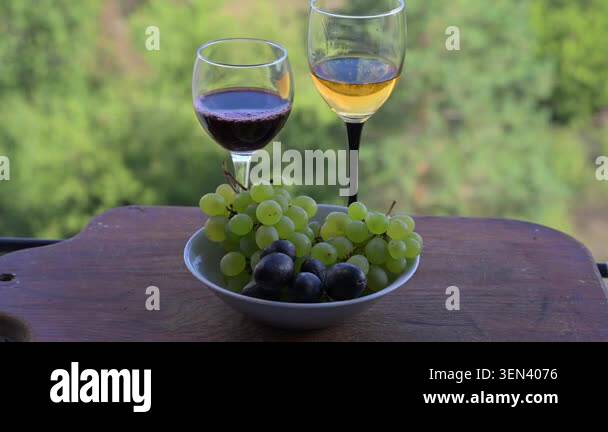 Fresh green grapes with wine glasses on a wooden table against a ...