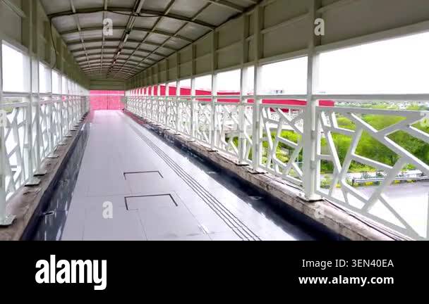Modern Covered Pedestrian Bridge with Geometric Railings and Urban View ...