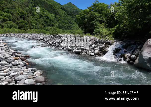 Clear river flowing through rocky landscape under sunlight Stock Video ...