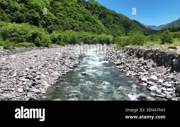 Clear river flowing through rocky landscape and greenery Stock Video ...