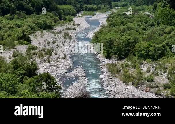 Clear river flowing through rocky landscape surrounded by greenery ...