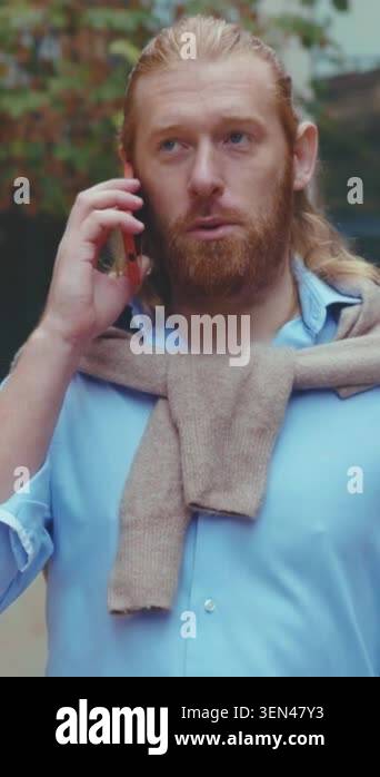 white man talking on phone outside with modern office backdrop, casual ...