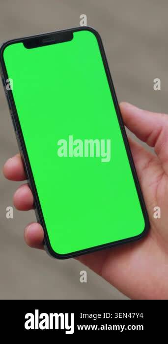 closeup of hand holding phone green screen, fingers tilting for message ...