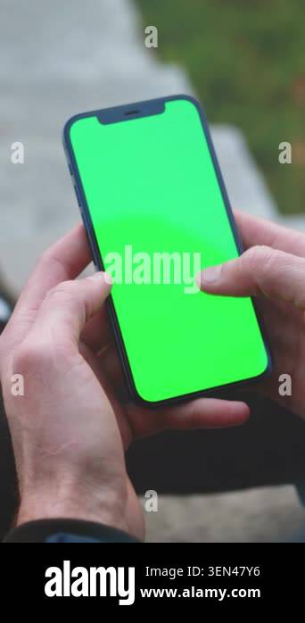 app developer testing prototype on phone with green screen, hands ...