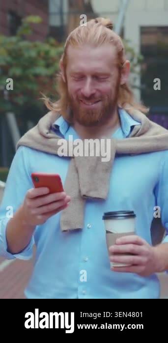 Smiling white man with coffee and phone, relaxed entrepreneur strolling ...