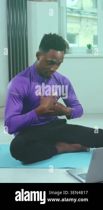 black man seated on mat breathing, virtual wellness coach guiding ...
