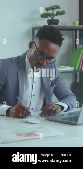Focused desk work with laptop and notes suited professional writes ...