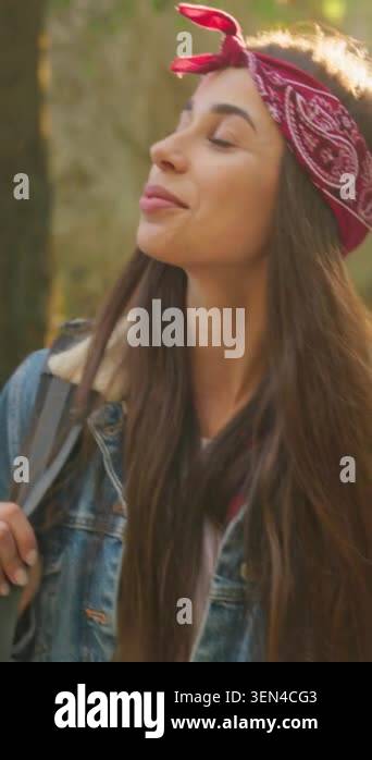 sunlit woman with bandana hiking, warm golden backlight on hair, denim ...
