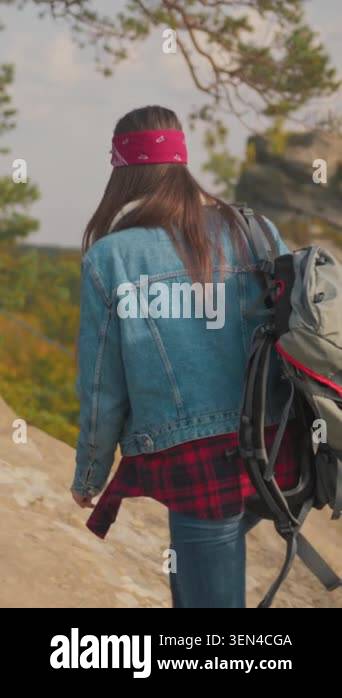 white woman hiker on rocky overlook wearing denim jacket and red ...