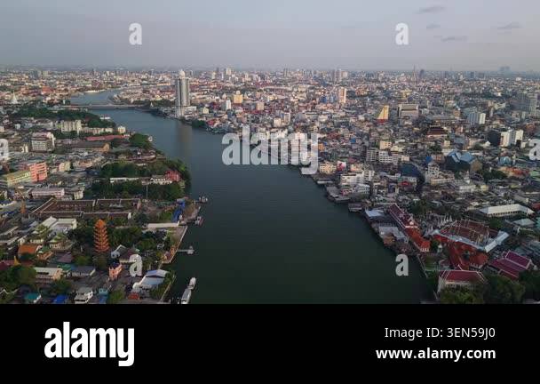 Aerial panorama of Chao Phraya River through historic Bangkok at golden ...
