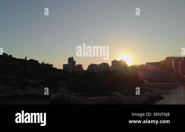 Calpe waterfront skyline at sunrise with coastal buildings and golden ...