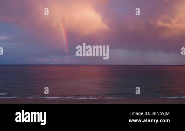 Rainbow over calm sea at sunset after rainstorm. Dramatic clouds ...