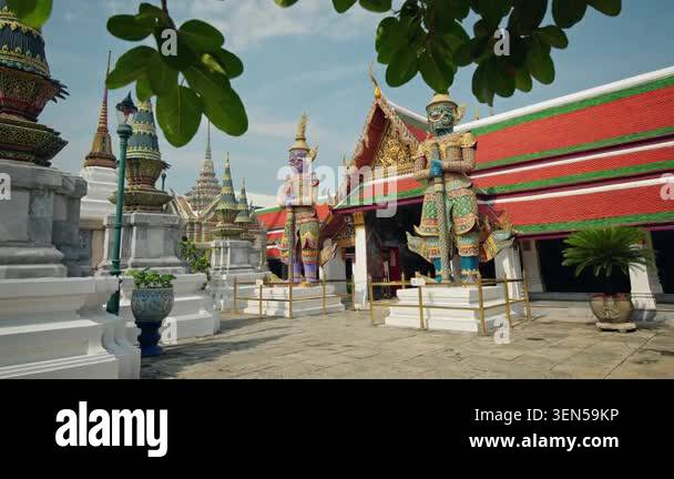 Traditional giant guardian statues at Wat Phra Kaew temple courtyard in ...