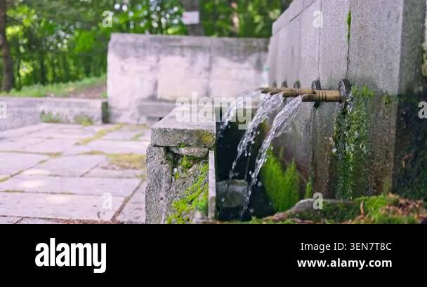 Natural spring water flowing from stone fountain near Buzludzha ...