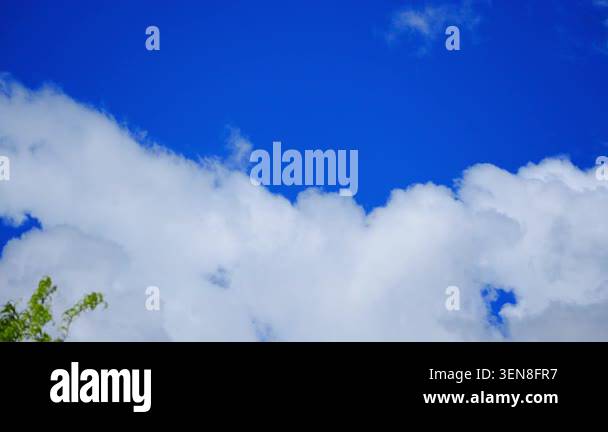 Time lapse of Large white clouds moving across deep blue sky . High ...