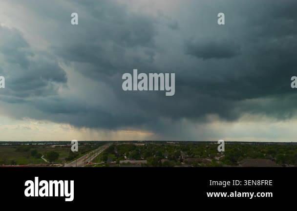 Massive storm clouds and heavy rain over suburban landscape captured ...