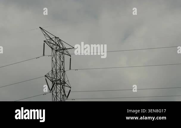 High voltage power lines tower standing against cloudy sky. High ...