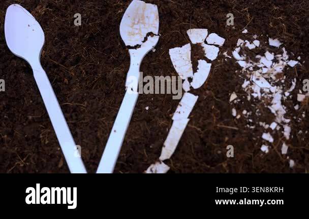 White plastic spoon breaking down in soil showing environmental ...