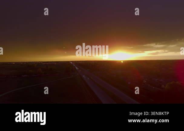 Golden sunset over suburban city skyline with heavy clouds and glowing ...