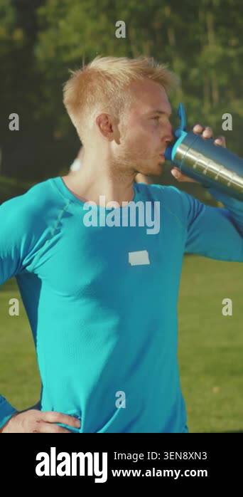 white male athlete drinking from bottle during cool down closeup ...