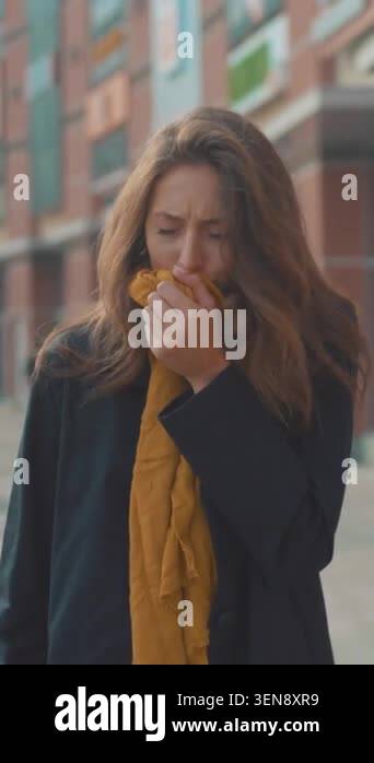 caucasian influencer outside clutching mustard scarf while sounding ...