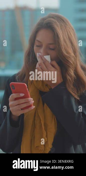 caucasian woman outdoors reading phone, dabbing tears with tissue and ...