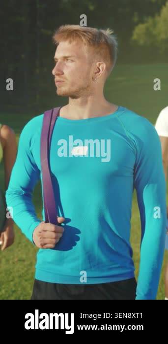 Caucasian athlete with resistance band outdoors, turquoise longsleeve ...