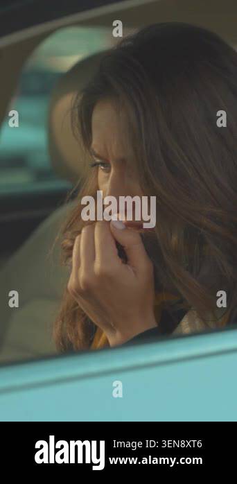 caucasian woman in car covering mouth and wiping eyes, sitting inside ...