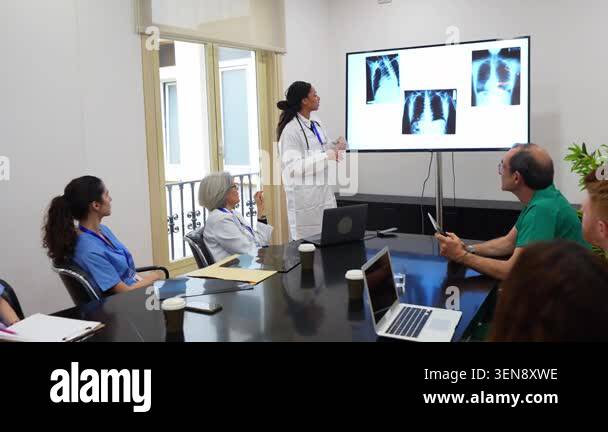 Young female doctor presenting a patient's lung x ray diagnosis to a ...