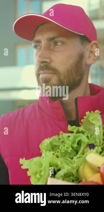 deliveryman holding paper grocery bag filled with lettuce bananas ...