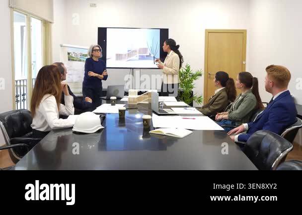 Young female architect presenting a new building design to her ...
