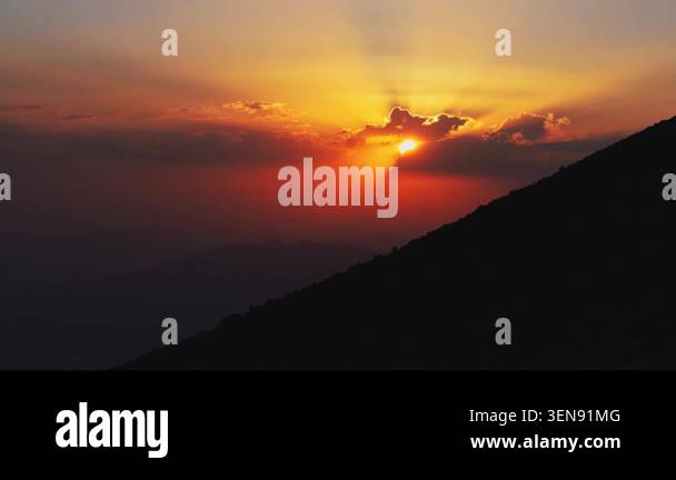 Cinematic mountain sunset sun rays piercing through clouds dramatic ...