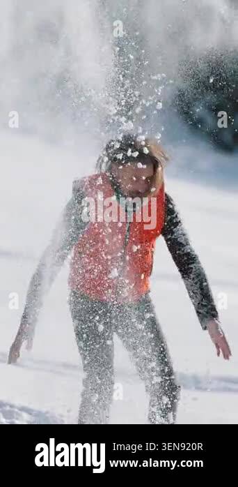 Man plays in the snow while throwing powder around in a winter ...