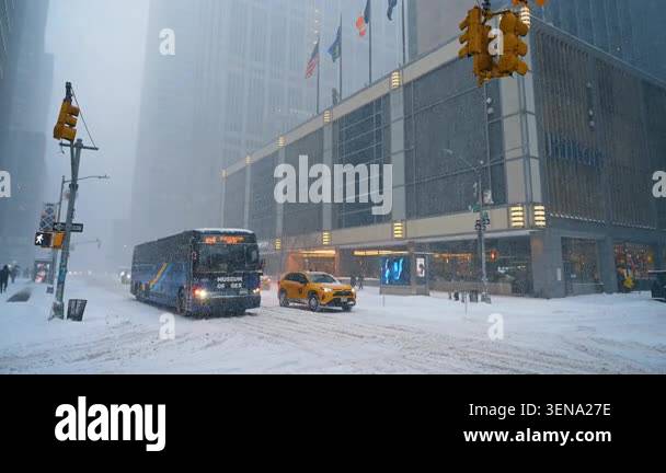 New York, USA, 9 January 2026: Yellow taxi and city bus driving past ...