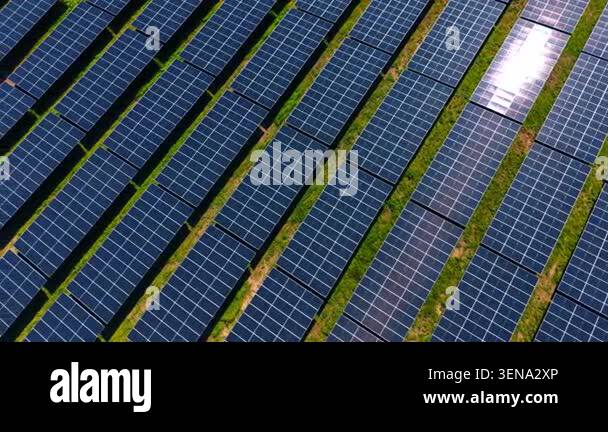 Overhead pattern of solar panel rows separated by green grass. Top-down ...