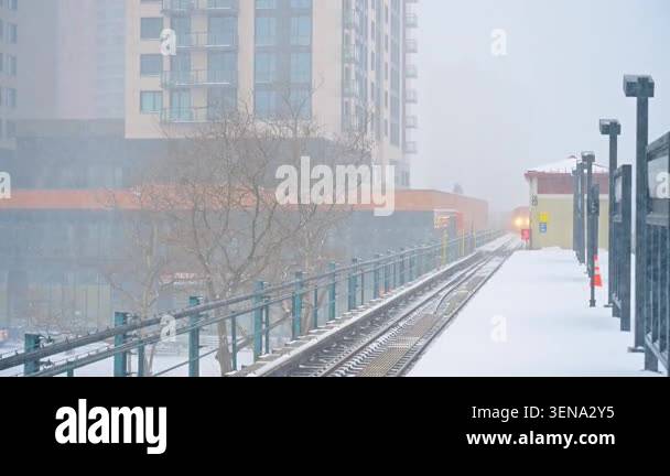 Train with headlights on arrives to the empty open-air subway station ...