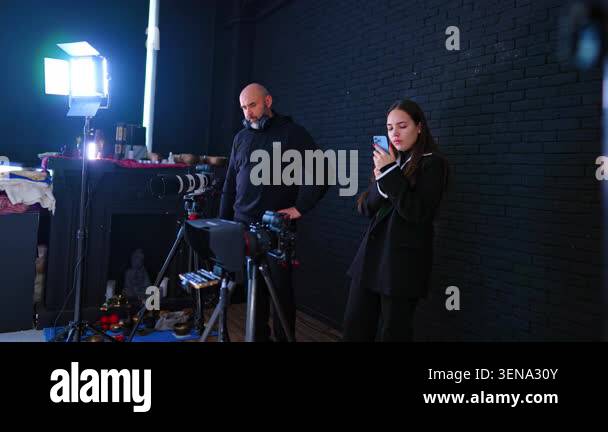 Film crew filming interview in dark studio with cinema light. Bearded ...