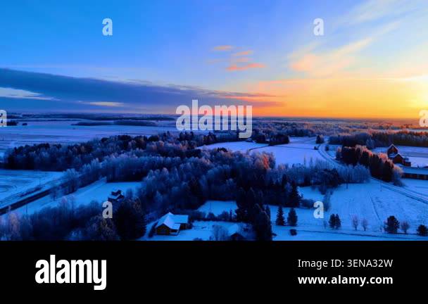 Sunset glow over winter farmland and village, Lapland, Finland. Snow ...