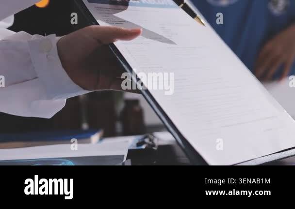 close up image of a doctor hand writing on a clipboard in hospital ...