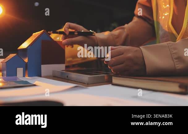 close up of woman engineer engineer holding house model and using ...