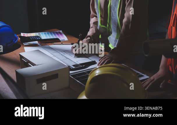 construction worker using laptop and blueprint for engineering project ...