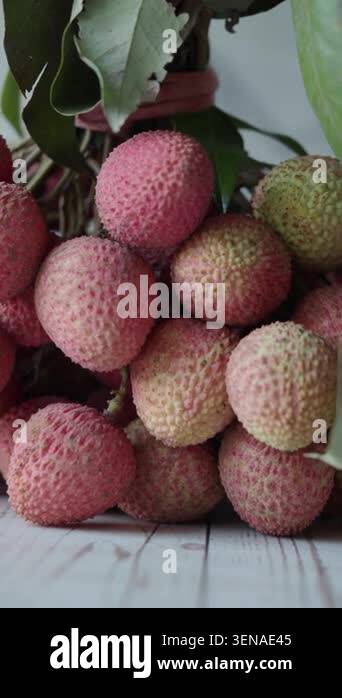 Lychee fruit is shown in detail with green leaves around it Stock Video ...
