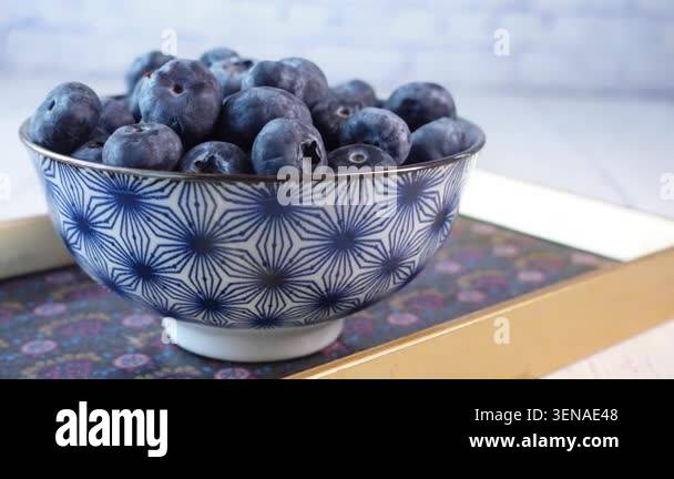 A bowl of fresh blueberries is placed on a tray for a healthy snack ...