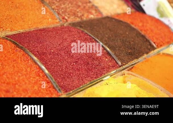 A variety of spices are arranged in bowls in a busy market Stock Video ...