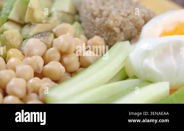 Preparing a plate with chickpeas, cucumber, and boiled egg for lunch ...