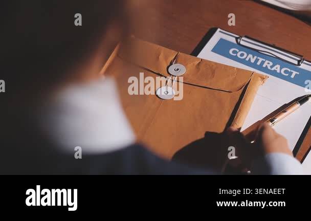 woman holding pen and writing paper on wooden desk in office Stock ...