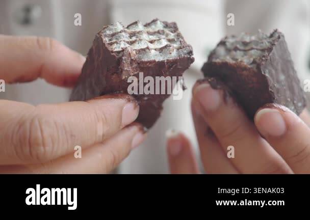 Two hands hold chocolate pieces made from an easy recipe with fun steps ...