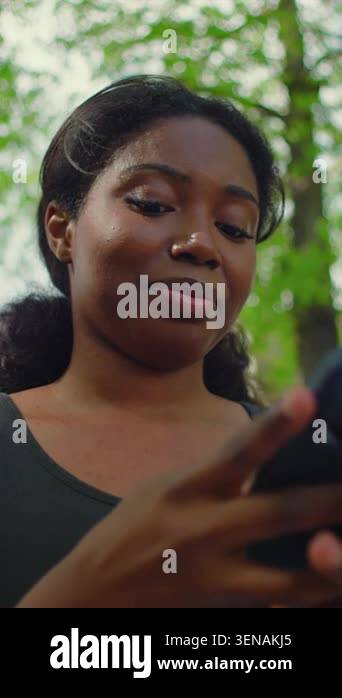 Young African American Woman posing in peaceful park setting with ...