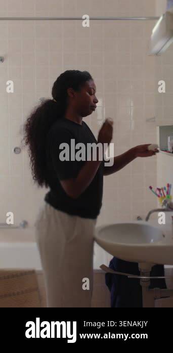 Young African American Woman gently applying toner to skin while ...