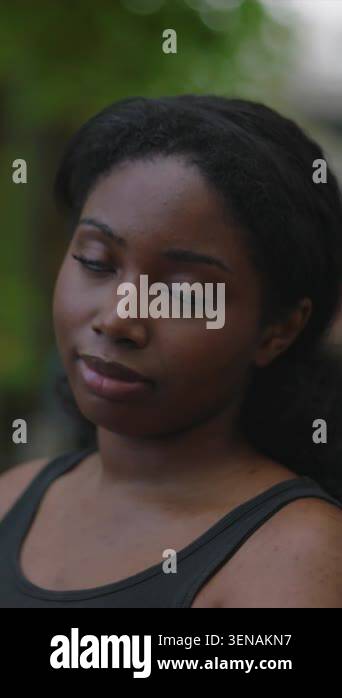 Young African American Woman posing in green park setting expressing ...